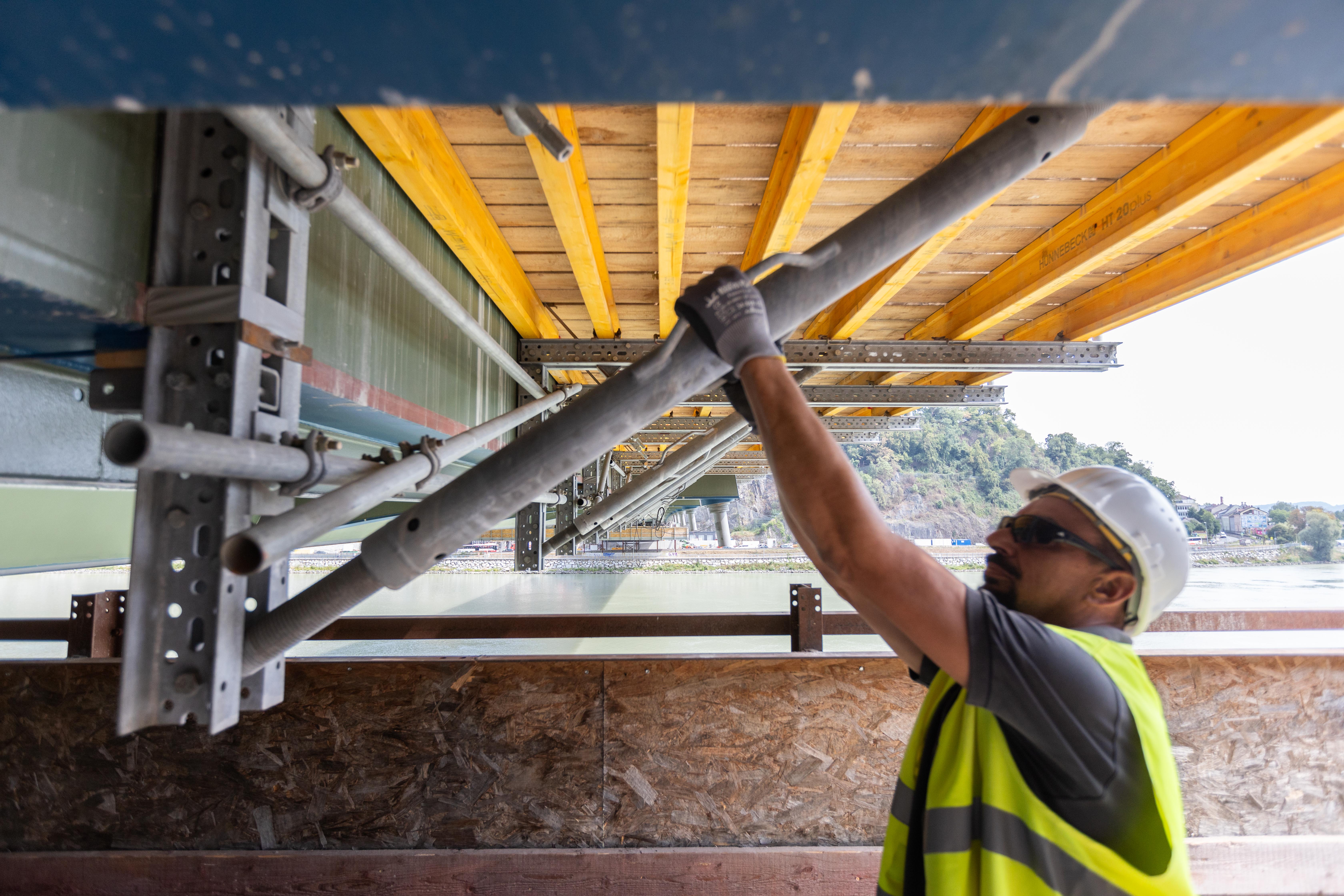 Suspended bridge construction with floating access platforms