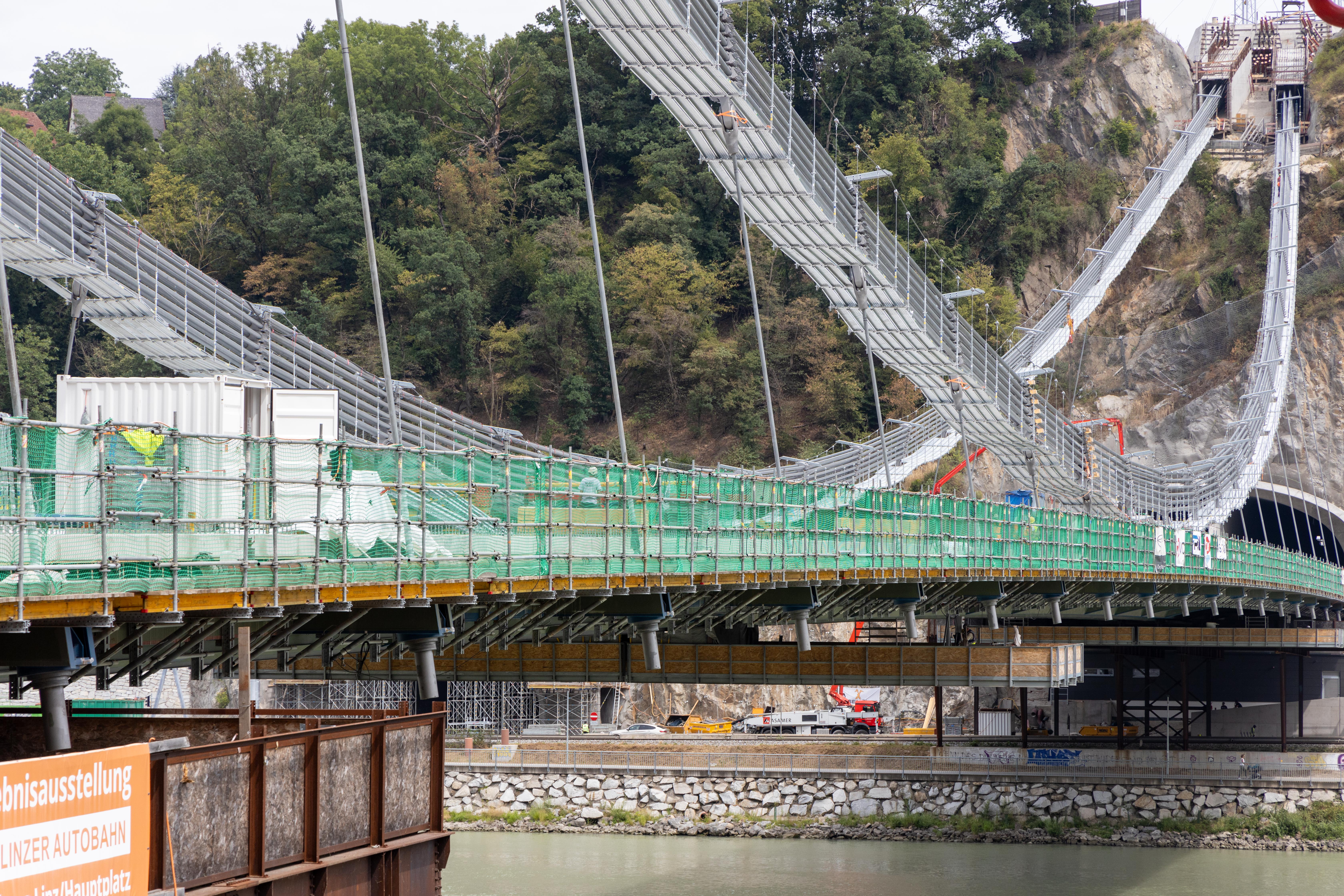 Suspended bridge construction with floating access platforms