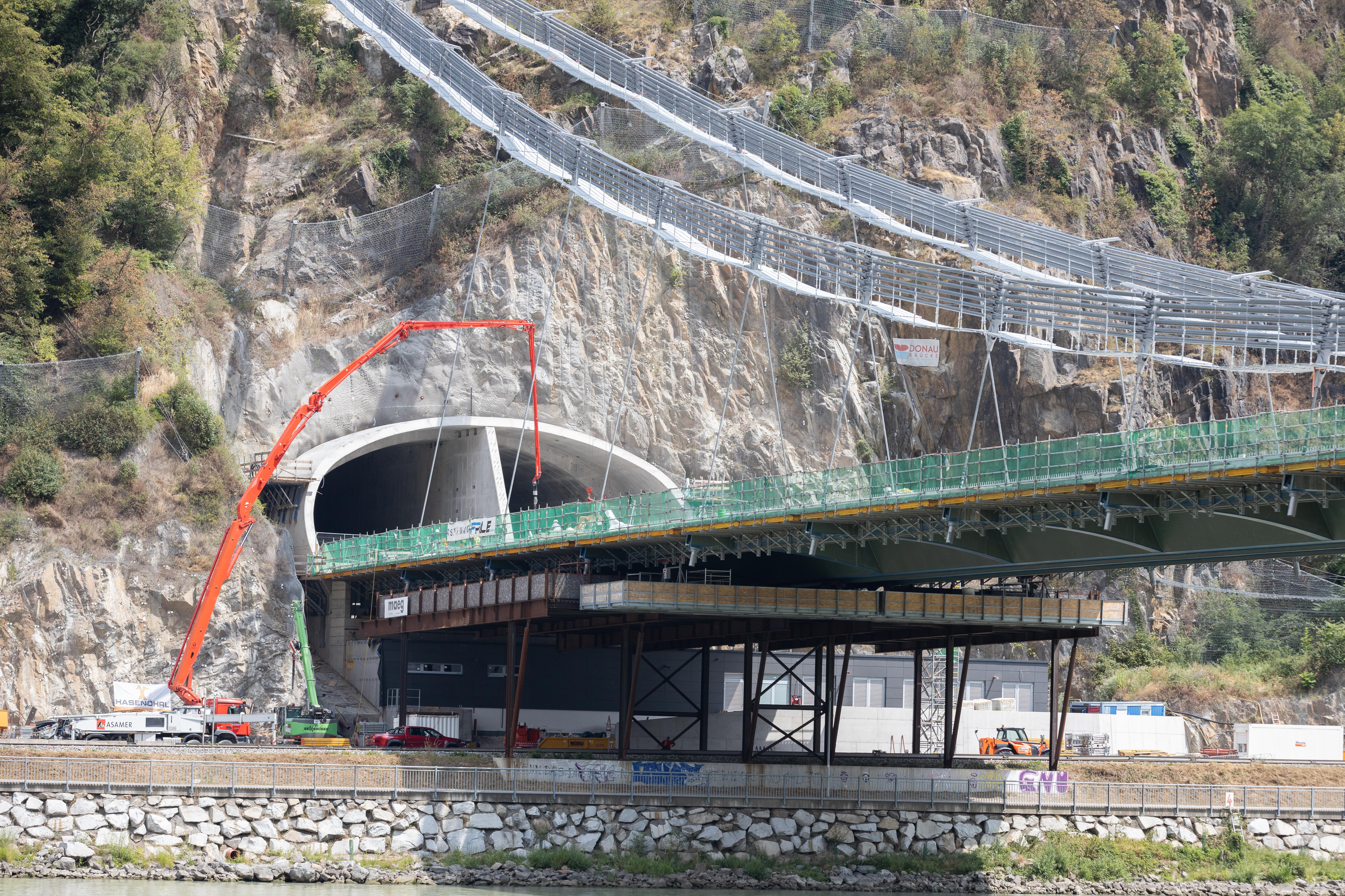 Suspended bridge construction with floating access platforms